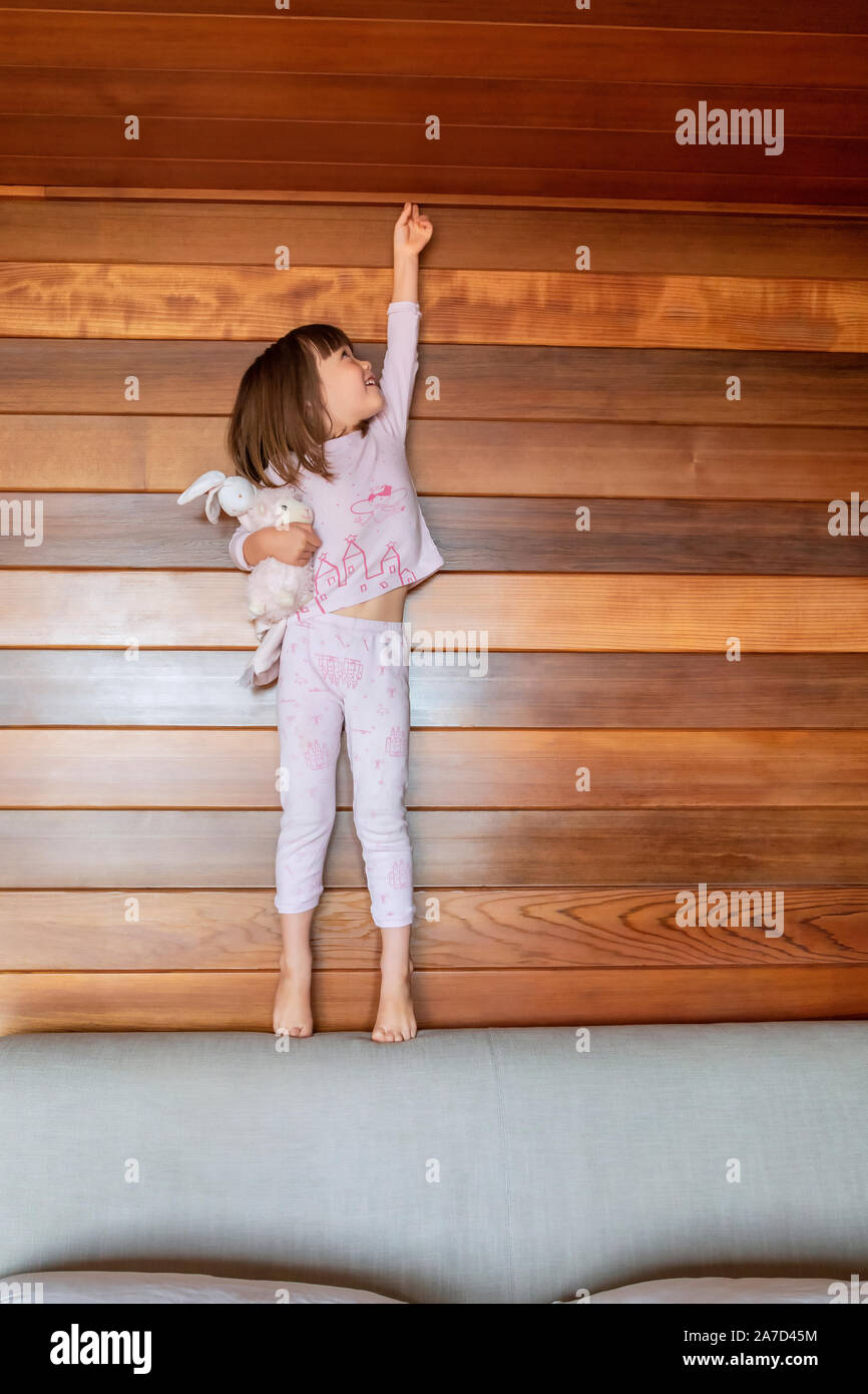 FIve year old girl trying to touch the ceiling Stock Photo - Alamy