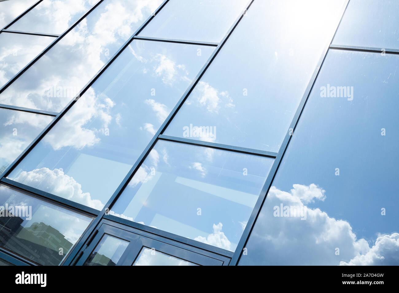 Glass building facade with blue sky reflection Stock Photo - Alamy