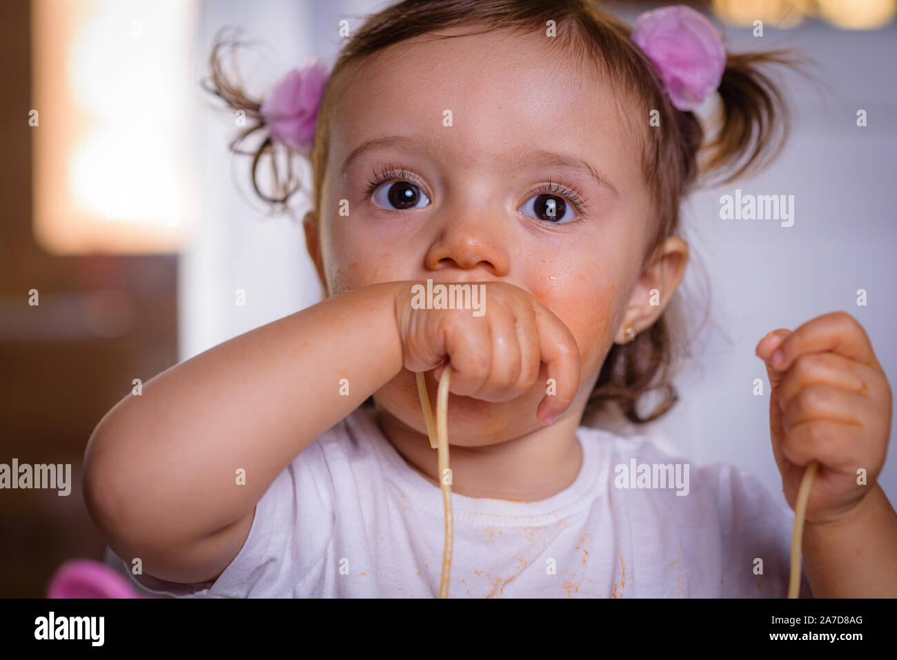 Adorable little girl eating spaghetti with Bolognese sauce with her ...