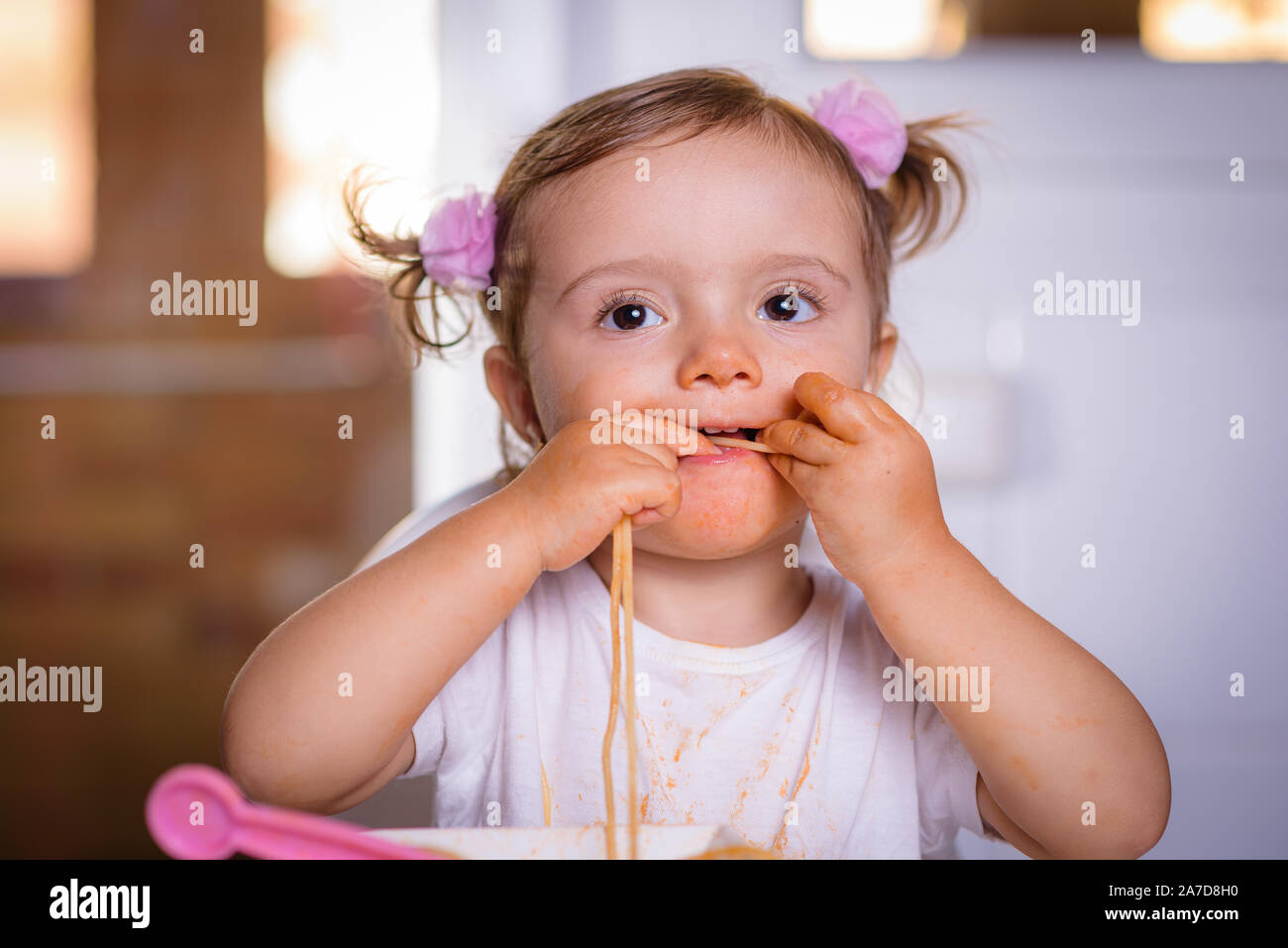 Adorable little girl eating spaghetti with Bolognese sauce with her ...