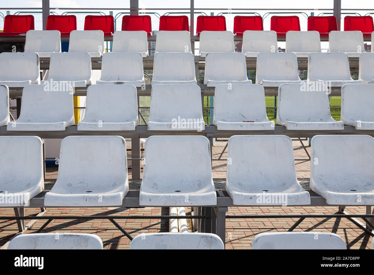 Front view of dirty white and red plactic seats on sport stadium's ...