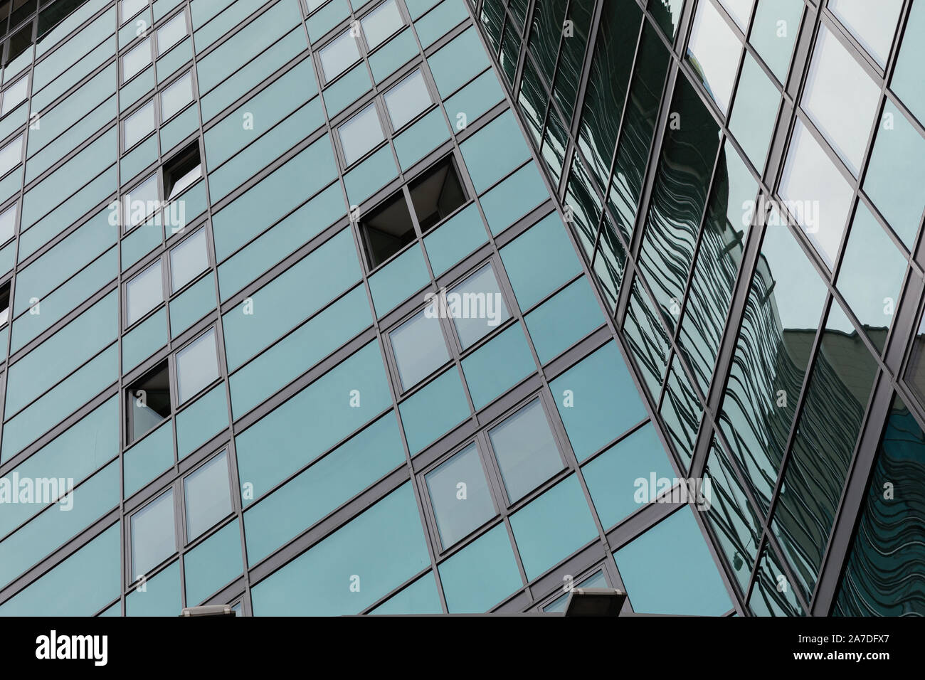 Ground view of innovative glass building facade with some open windows ...