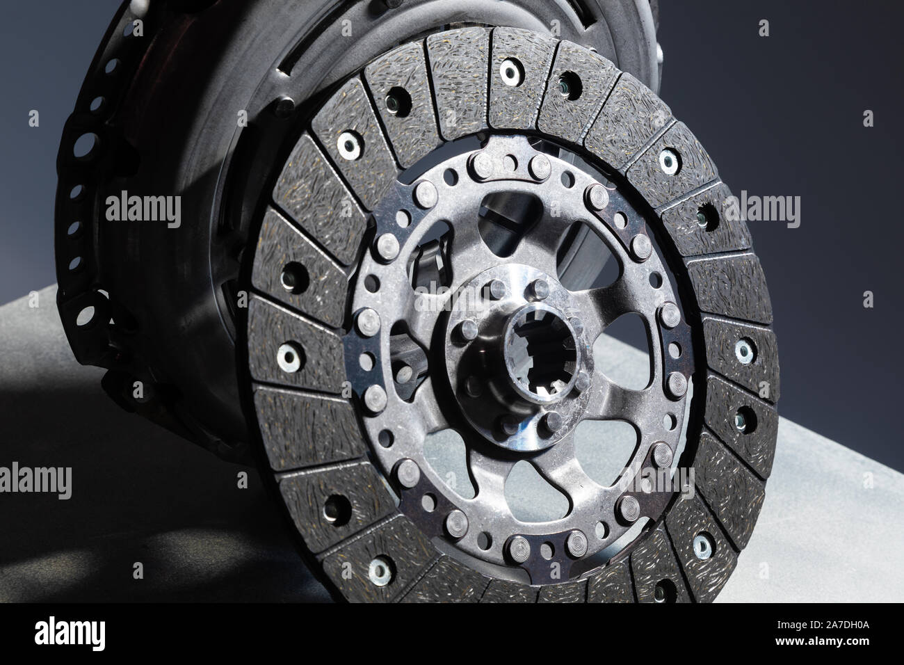 Close-up picture of a part of car, black clutch disk isolated on black ...