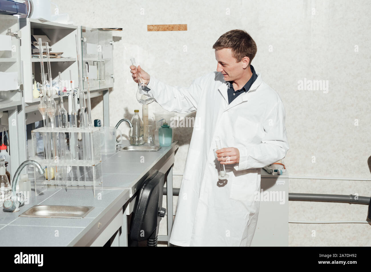 male scientist conducts chemical experiments with fluids in medical ...