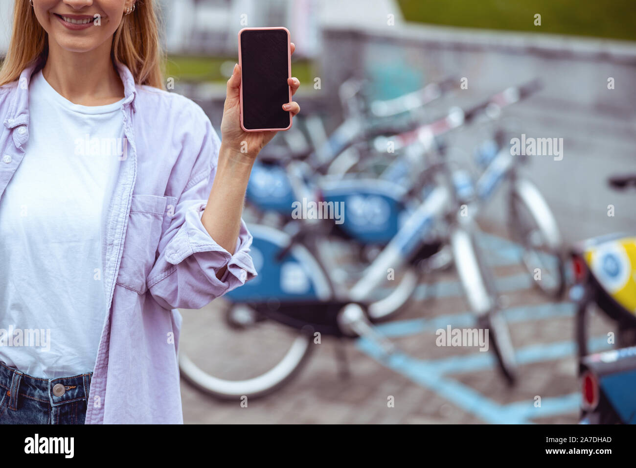 Lady with a gadget smiling at the camera Stock Photo - Alamy