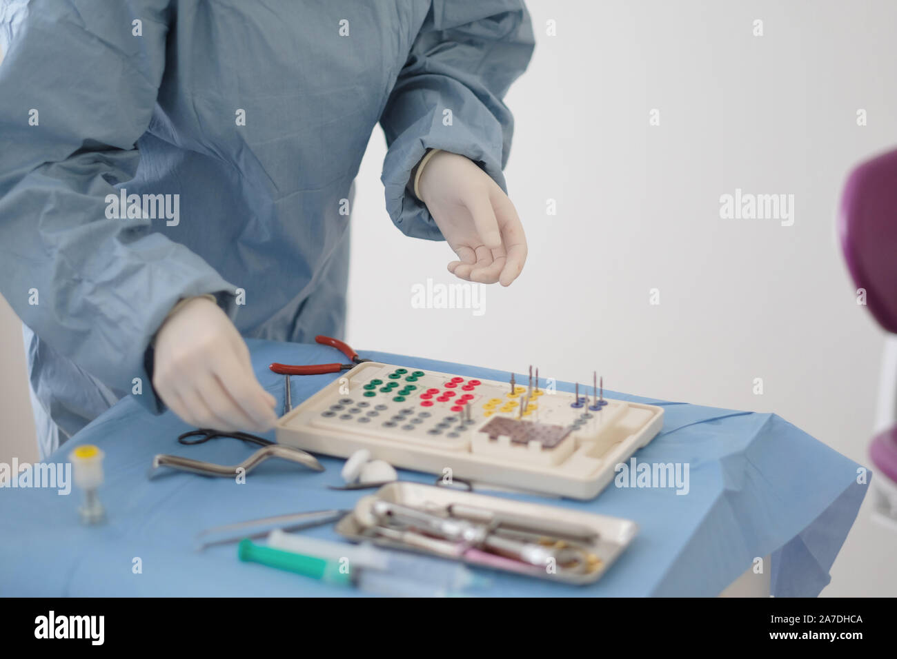 Doctor dentist takes a prepared instrument for dental surgery in the ...