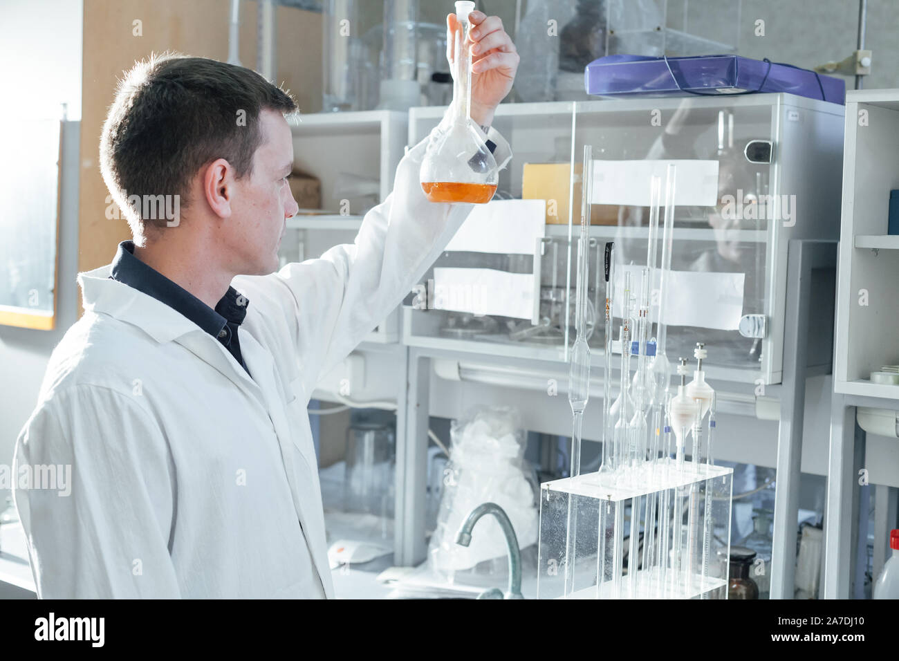 male scientist conducts chemical experiments with fluids in medical ...