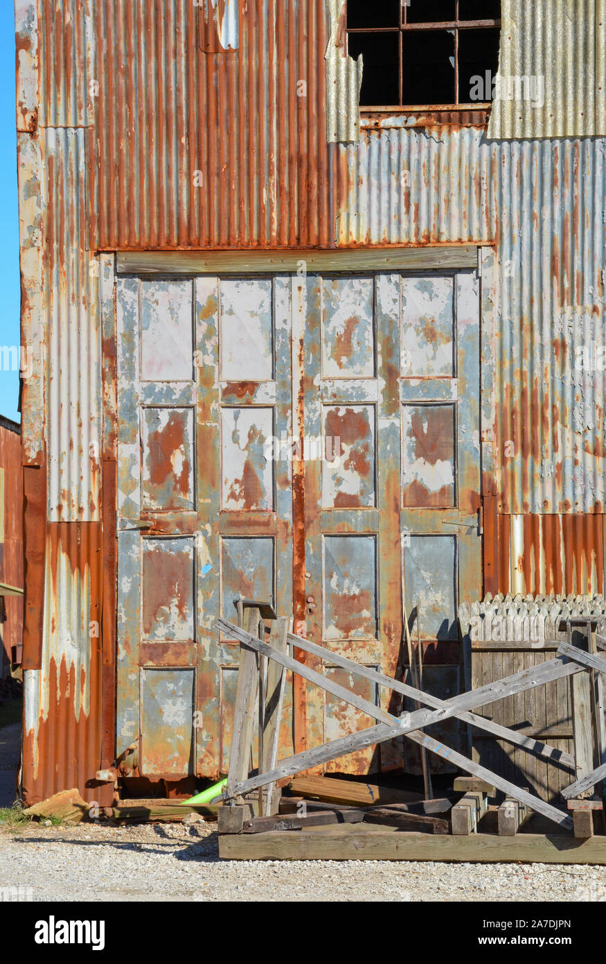 Rusty metal door against corrugated metal industrial building's wall ...