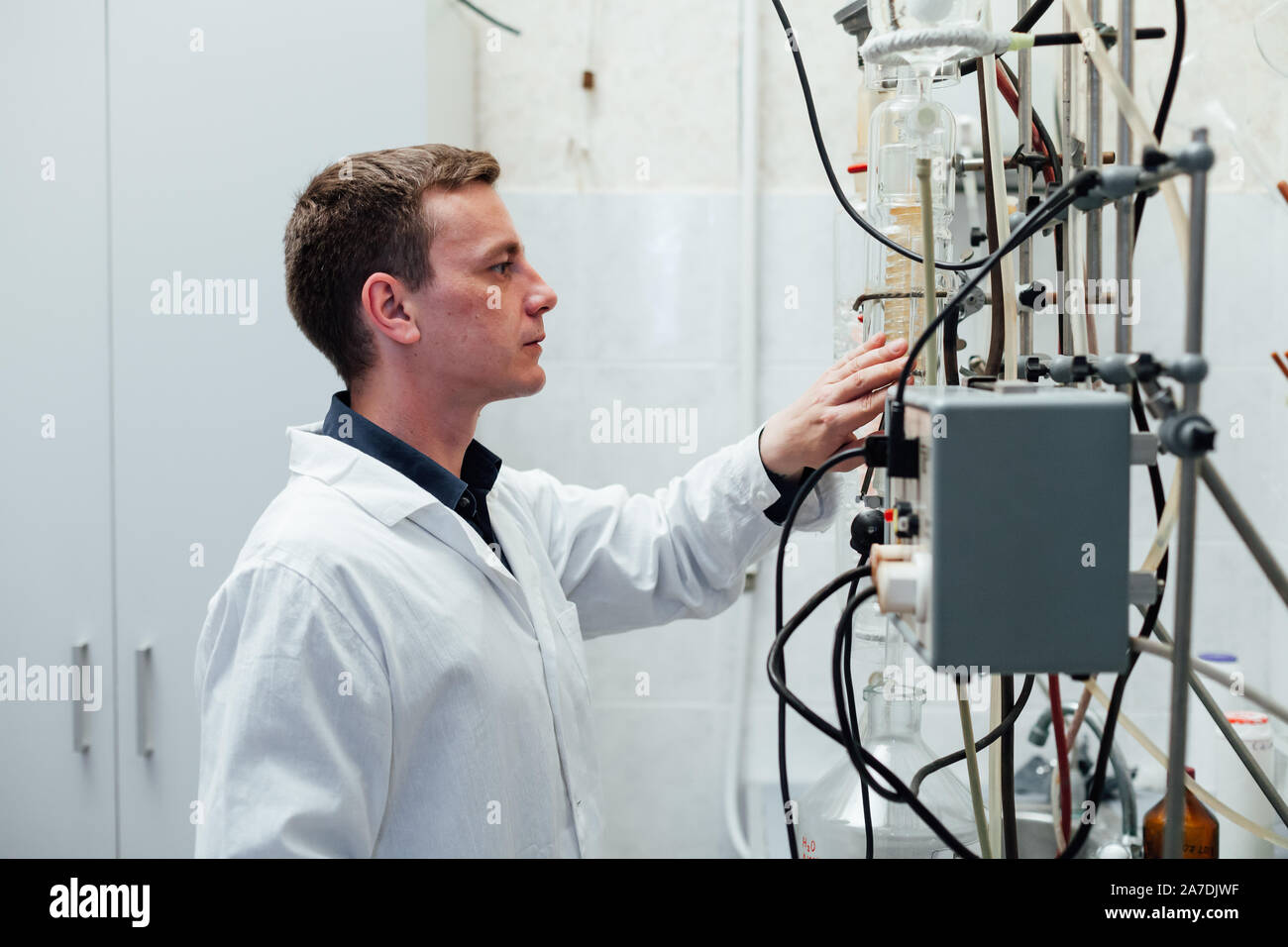 male scientist conducts chemical experiments with fluids in medical ...