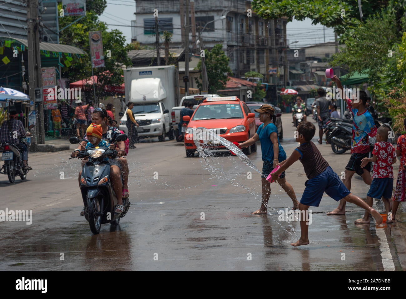 Children throw water during Songkran to a bike in Bangkok Stock Photo ...