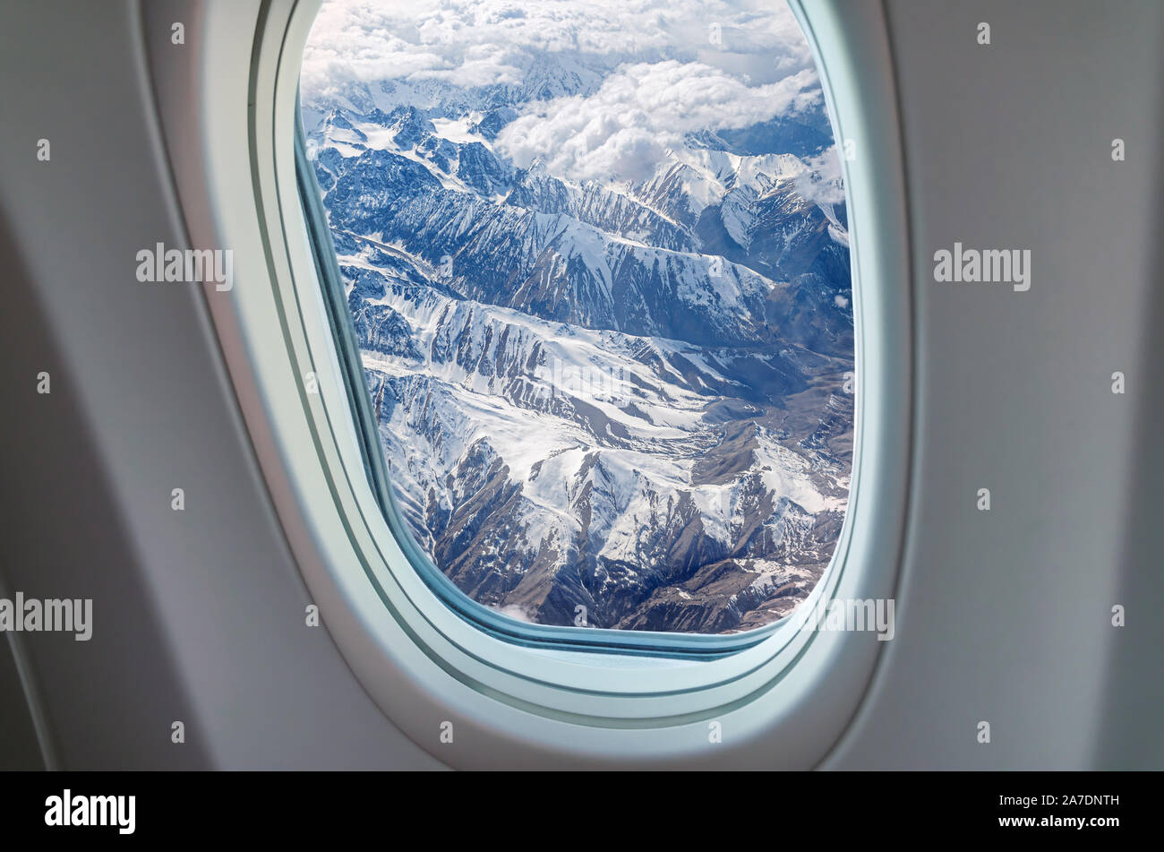 Incredible view from an airplane window on a snowy mountain range ...