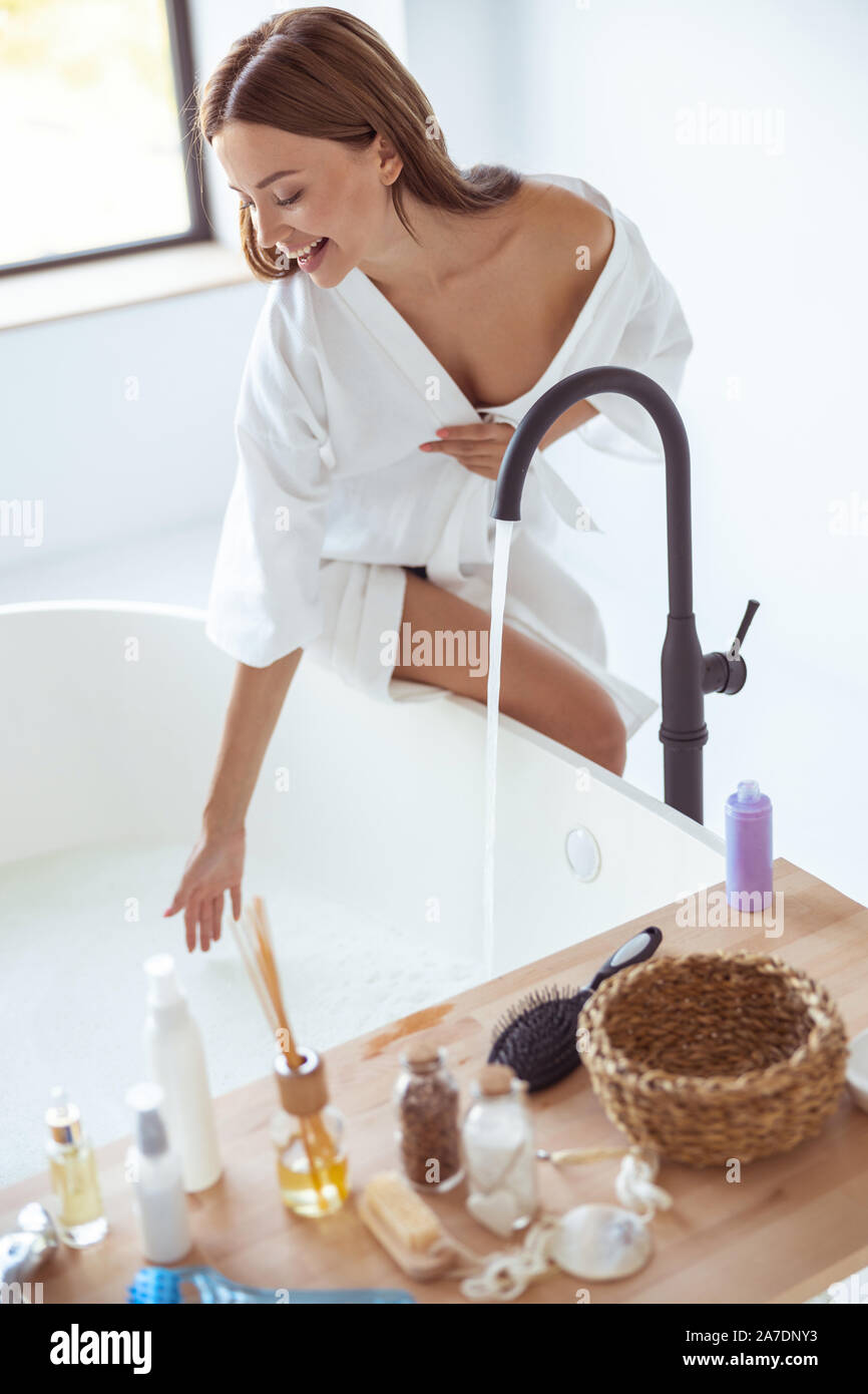 Cute brunette female preparing bath for procedure Stock Photo - Alamy