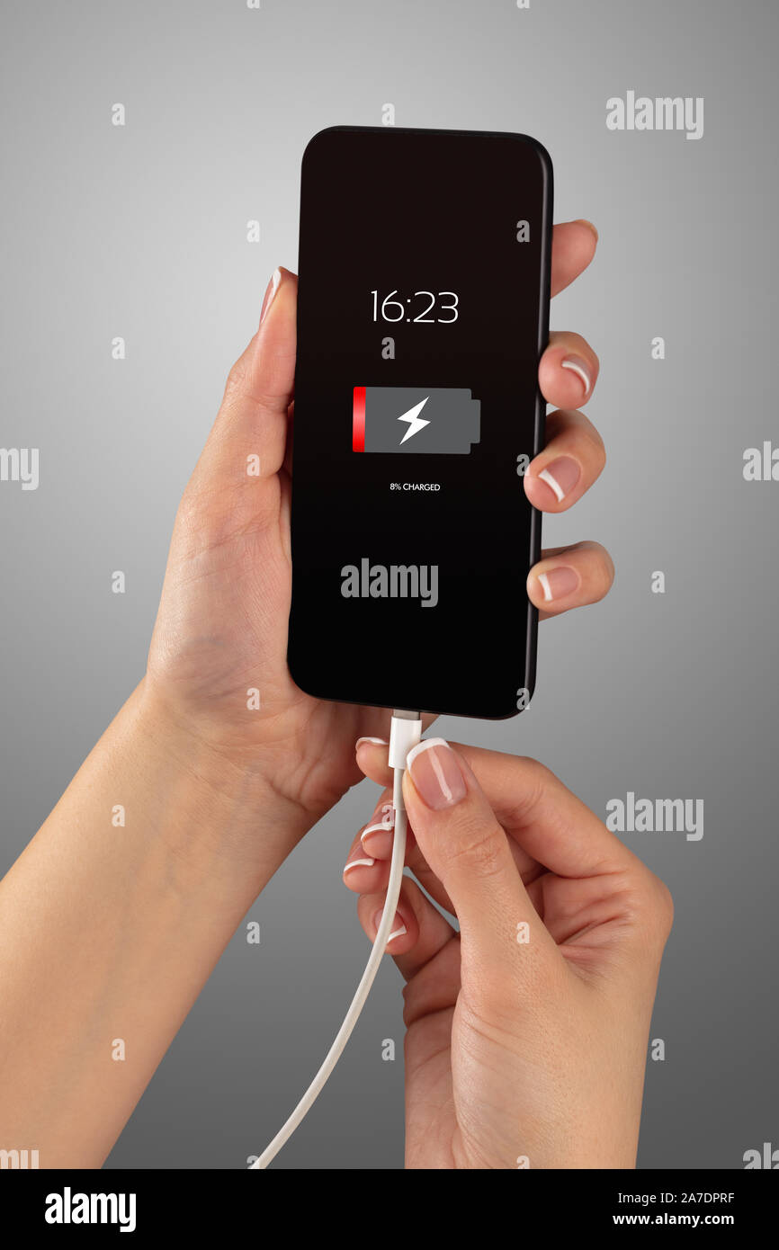 Elegant hand charging smartphone with low battery Stock Photo - Alamy