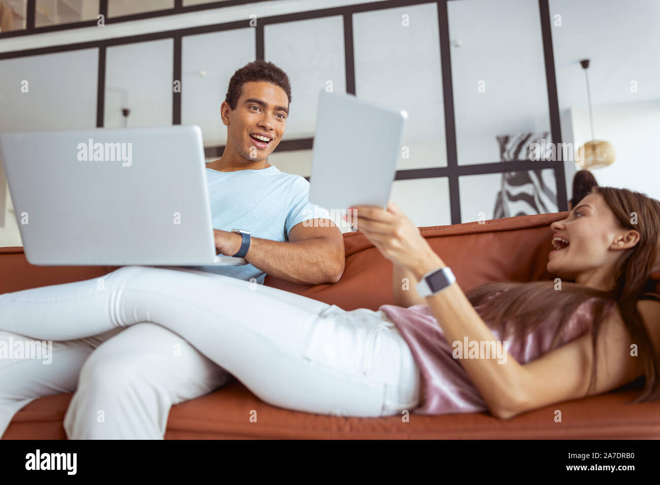 Delighted international man staring at screen of tablet Stock Photo - Alamy