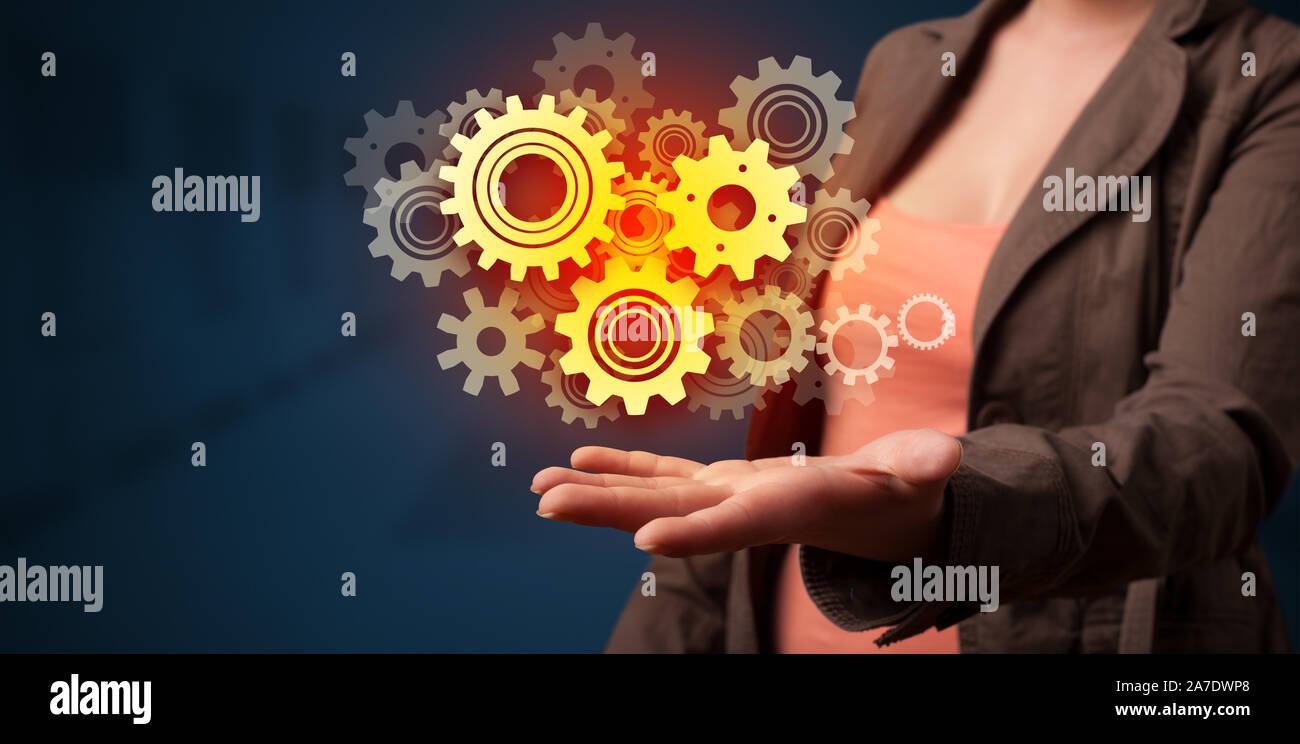 Hand holding gears in his hand Stock Photo - Alamy