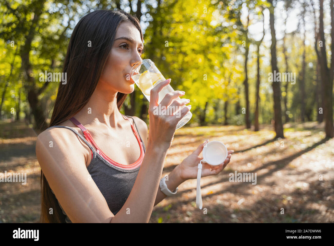 Beautiful woman drinking water after training outside Stock Photo - Alamy