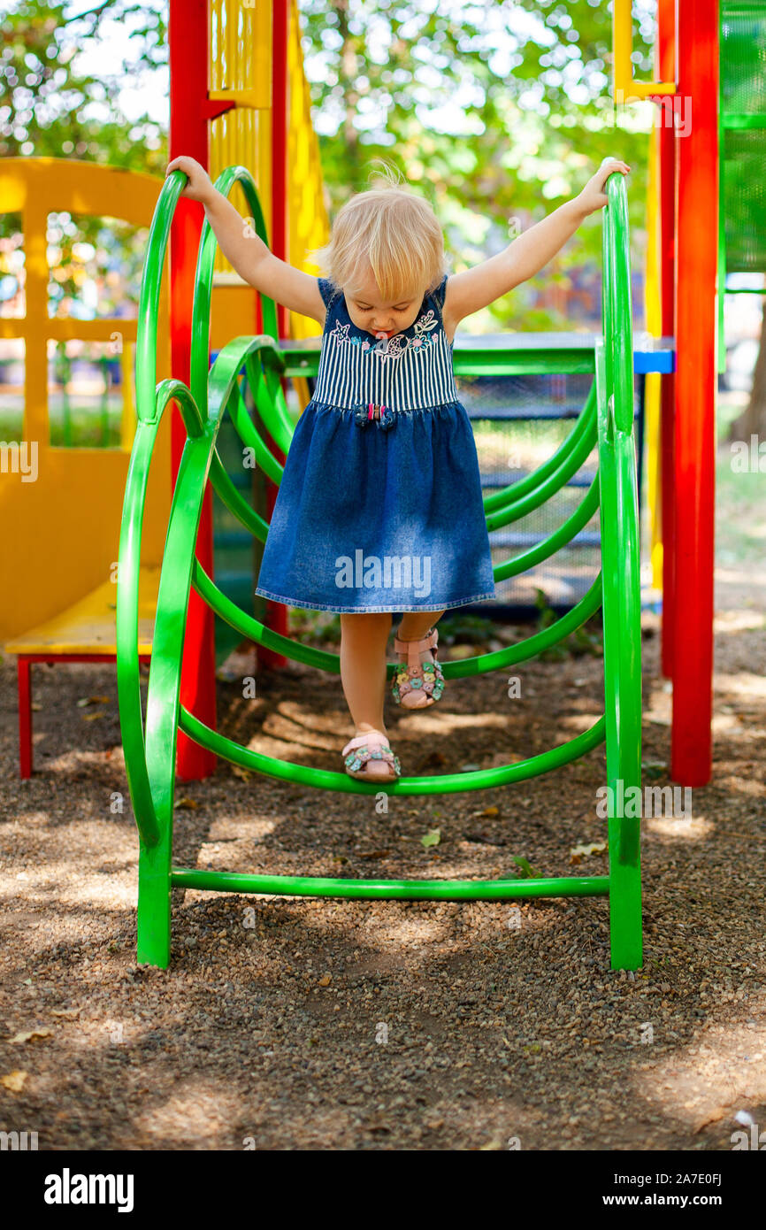 Child playing on outdoor playground. Little baby girl plays on school ...