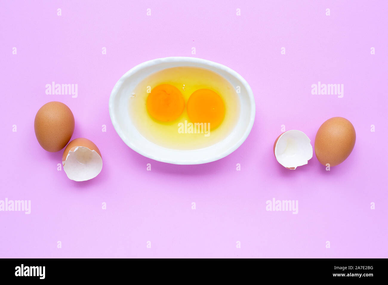 Two egg yolk and white in a bowl on pink background. Top view Stock ...