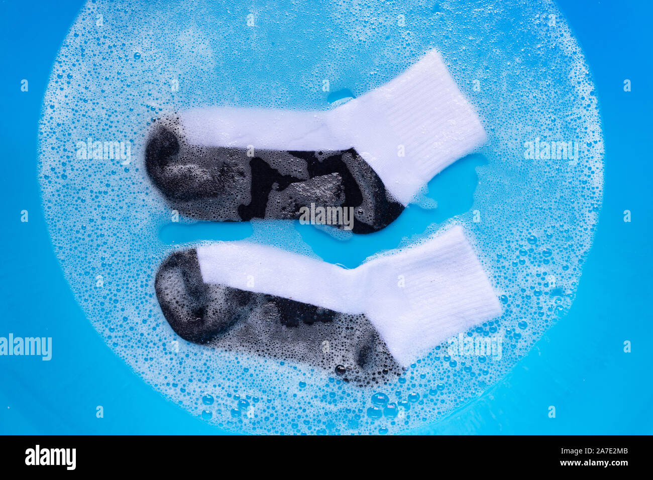 Dirty socks soaking in powder detergent water dissolution. Laundry ...