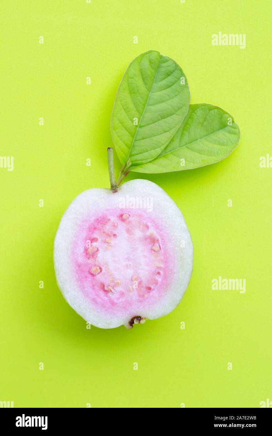 Top view of fresh ripe guava and slices with leaves on green background ...