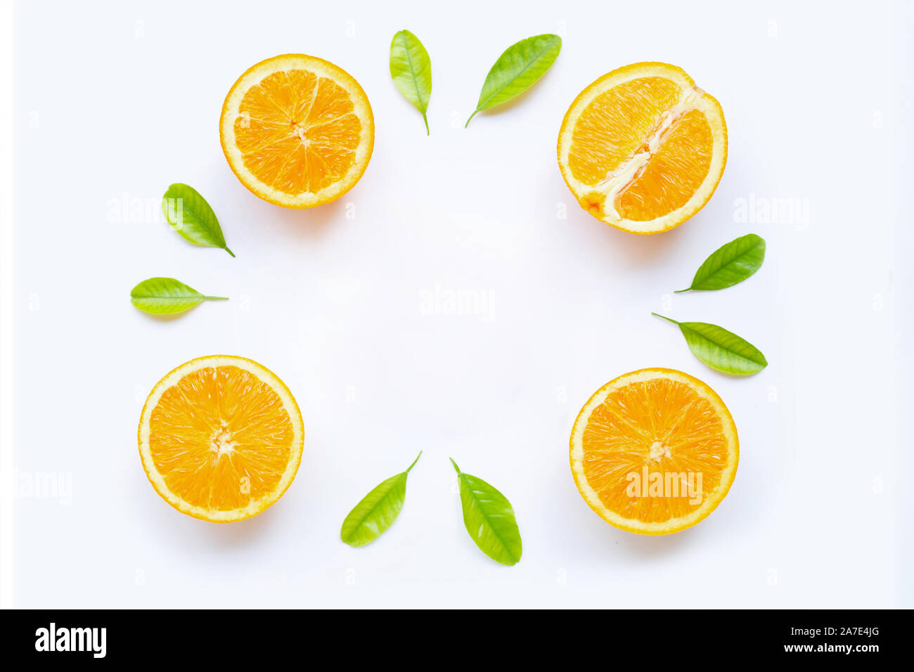 Frame made of fresh orange fruit with green leaves on white background ...