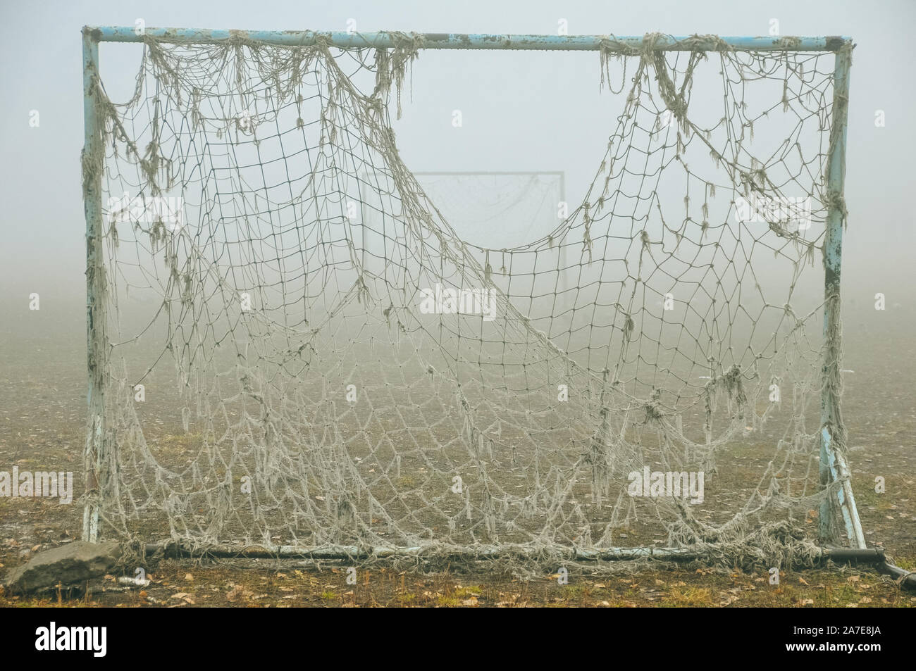 Old empty abandoned football field and gate with a tangled net in a ...
