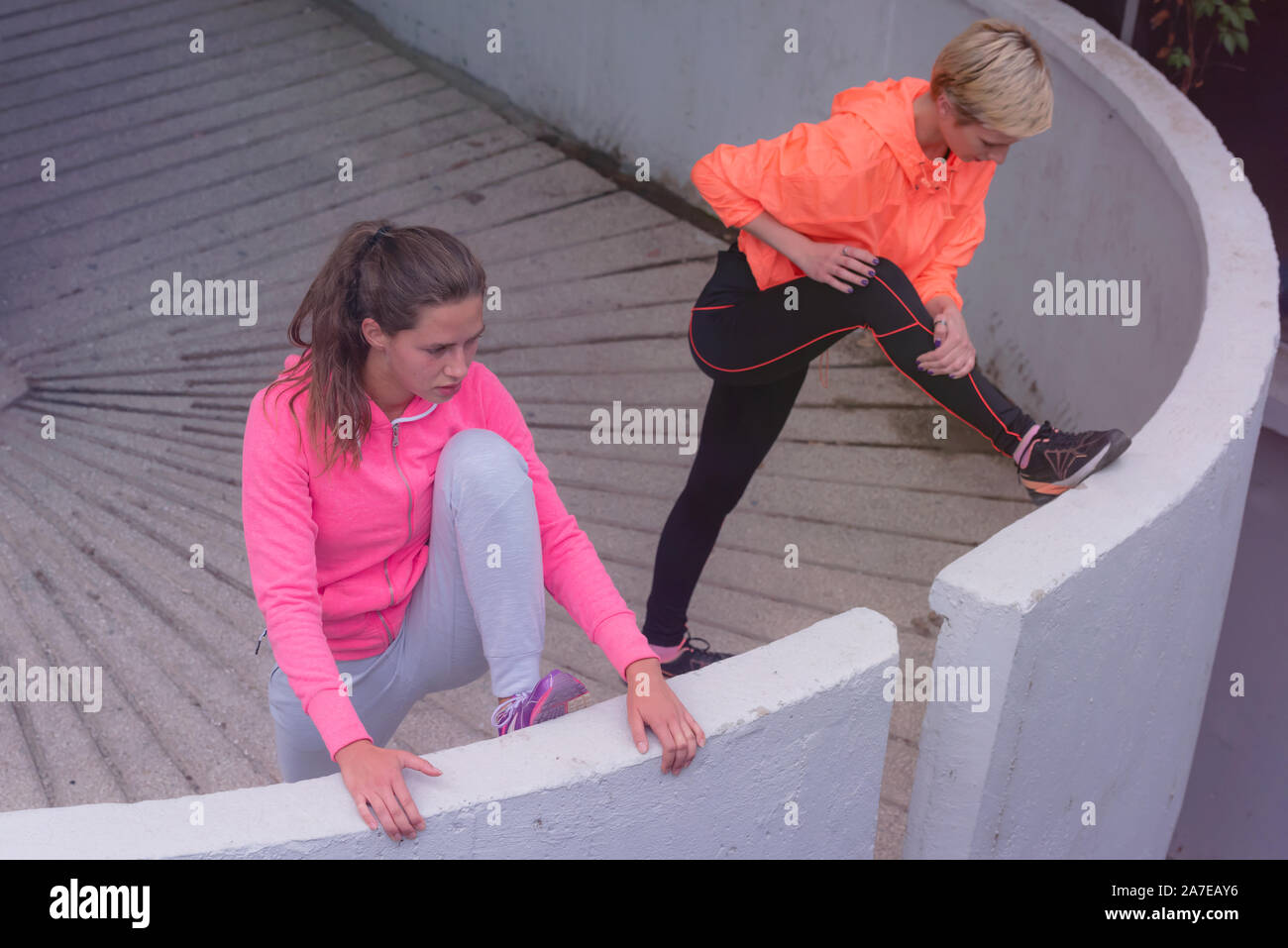 Two Young female runners prepairing for jogging in the city street. Fit ...