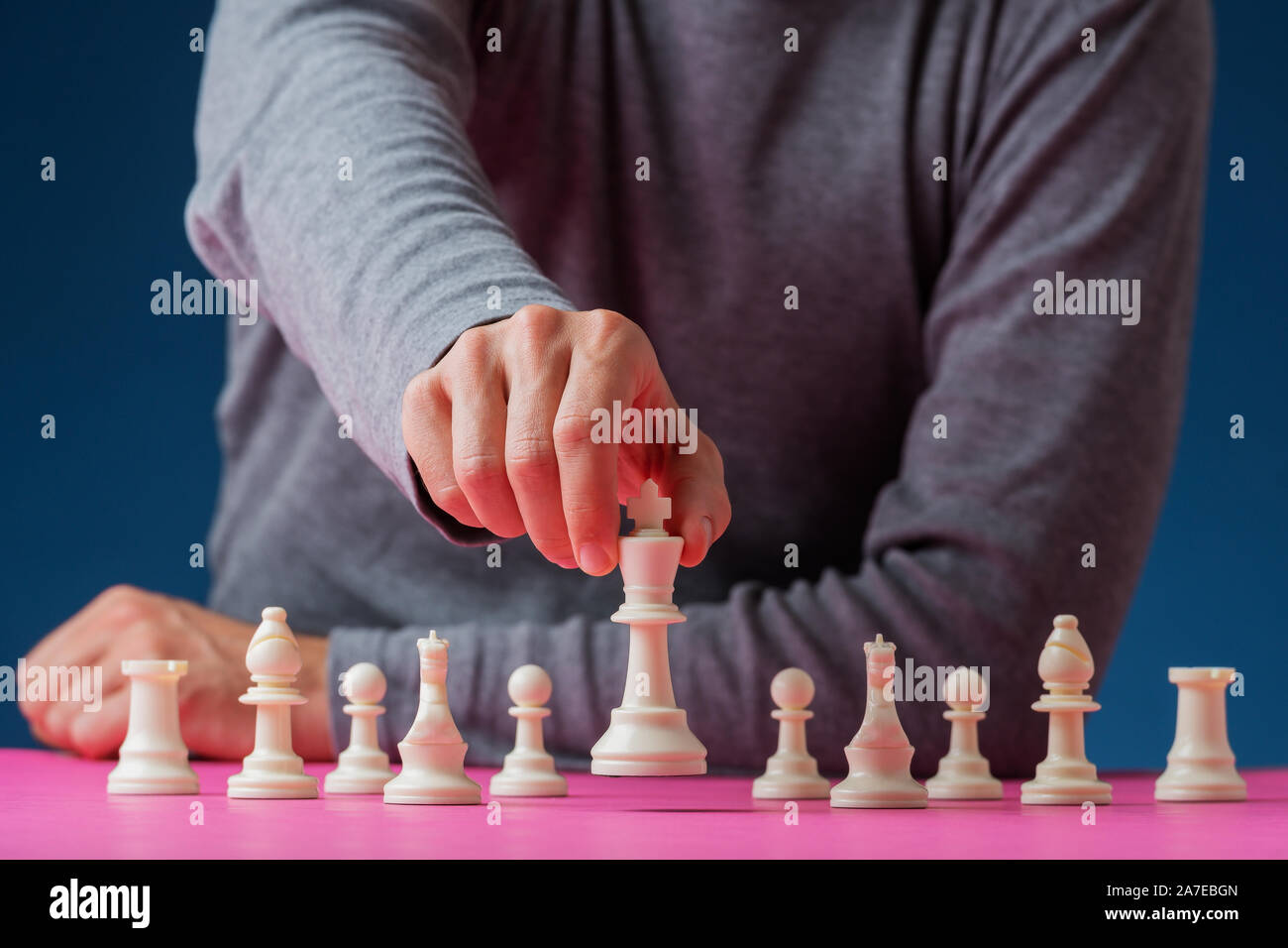 Front view of a man positioning white king chess piece in front of the ...