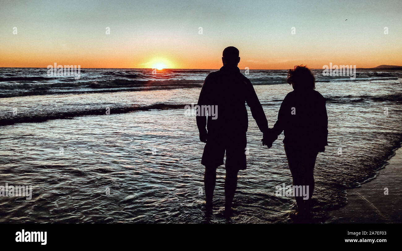 an old couple enjoying a lovely sunset at the beach Stock Photo - Alamy