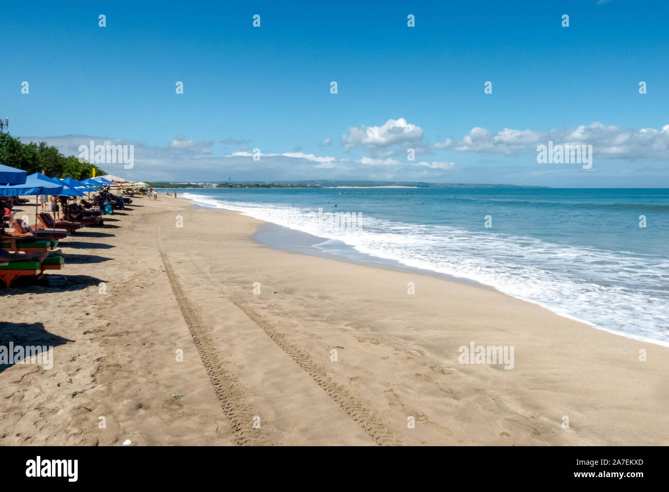 Long line of beach umbrellas on the beautiful calm Kuta beach in Bali ...