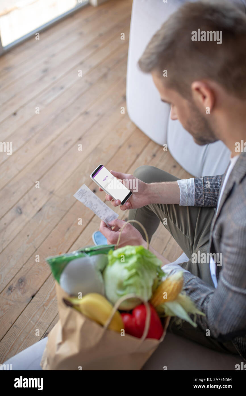 Top view of man double checking prices after buying food Stock Photo ...
