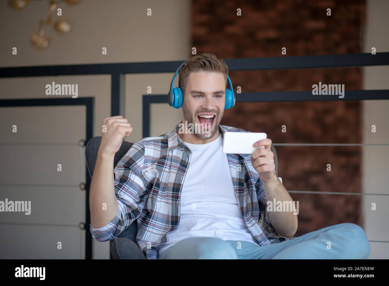 Emotional man enjoying weekend at home playing video game Stock Photo ...