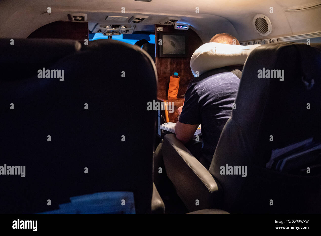 A man read book on the small private jet plane at the night under the ...