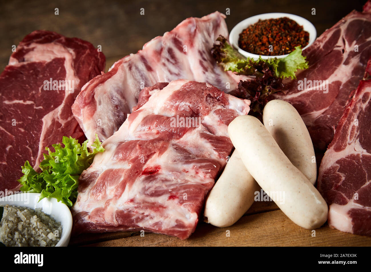 Raw spare ribs and pork or veal sausage displayed with assorted cuts of ...