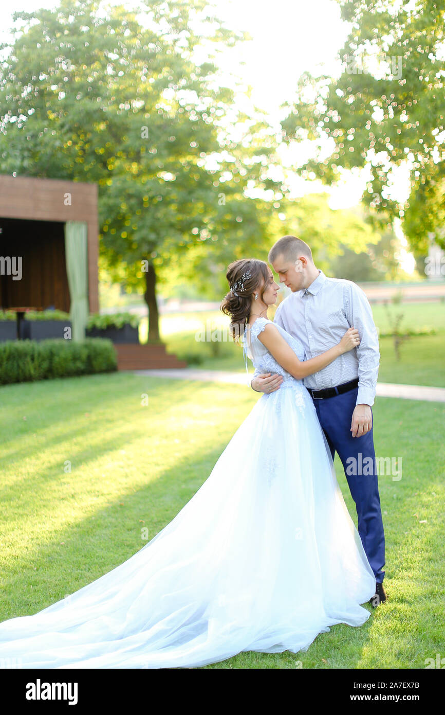 Amazing bride dancing in park with groom on shiny green grass Stock ...
