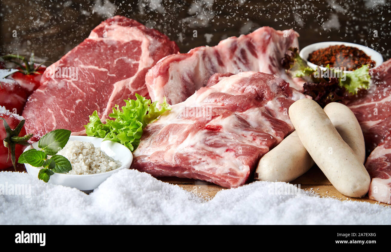 Assortment of fresh raw meat for a winter barbecue displayed on ...
