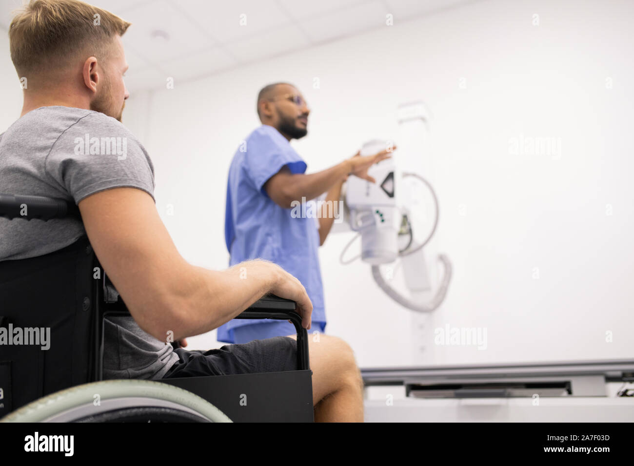 Young sick patient wheelchair looking at doctor testing new medical ...