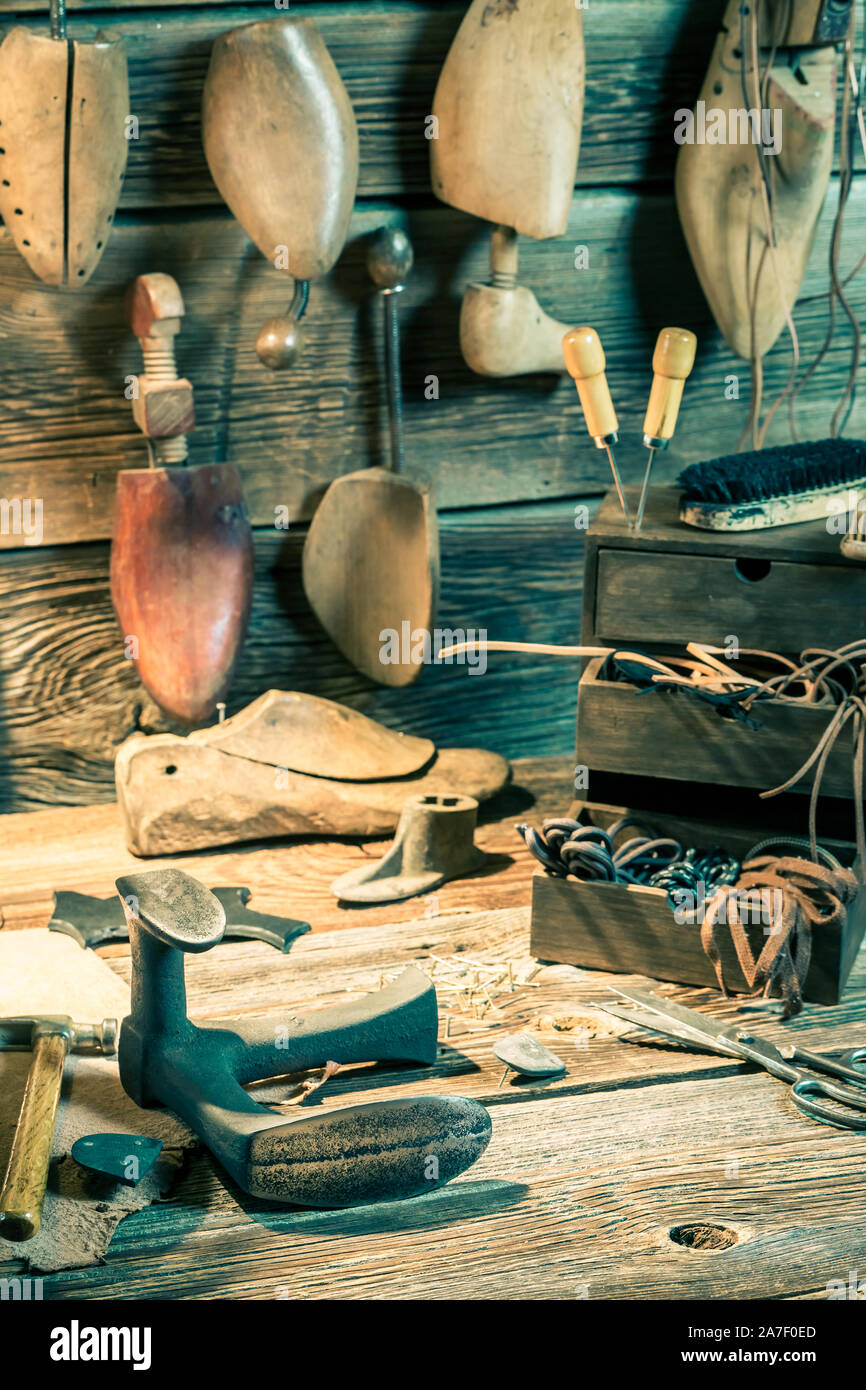 Shoemaker workplace with tools, leather and shoes to repair Stock Photo ...