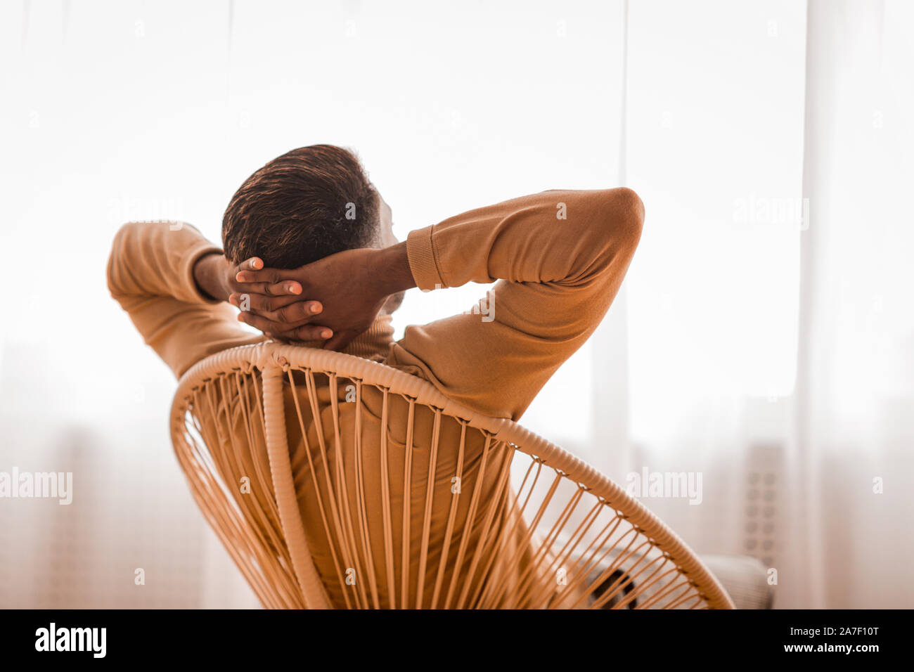 Man Sitting On Modern Chair Back To Camera At Home Stock Photo - Alamy