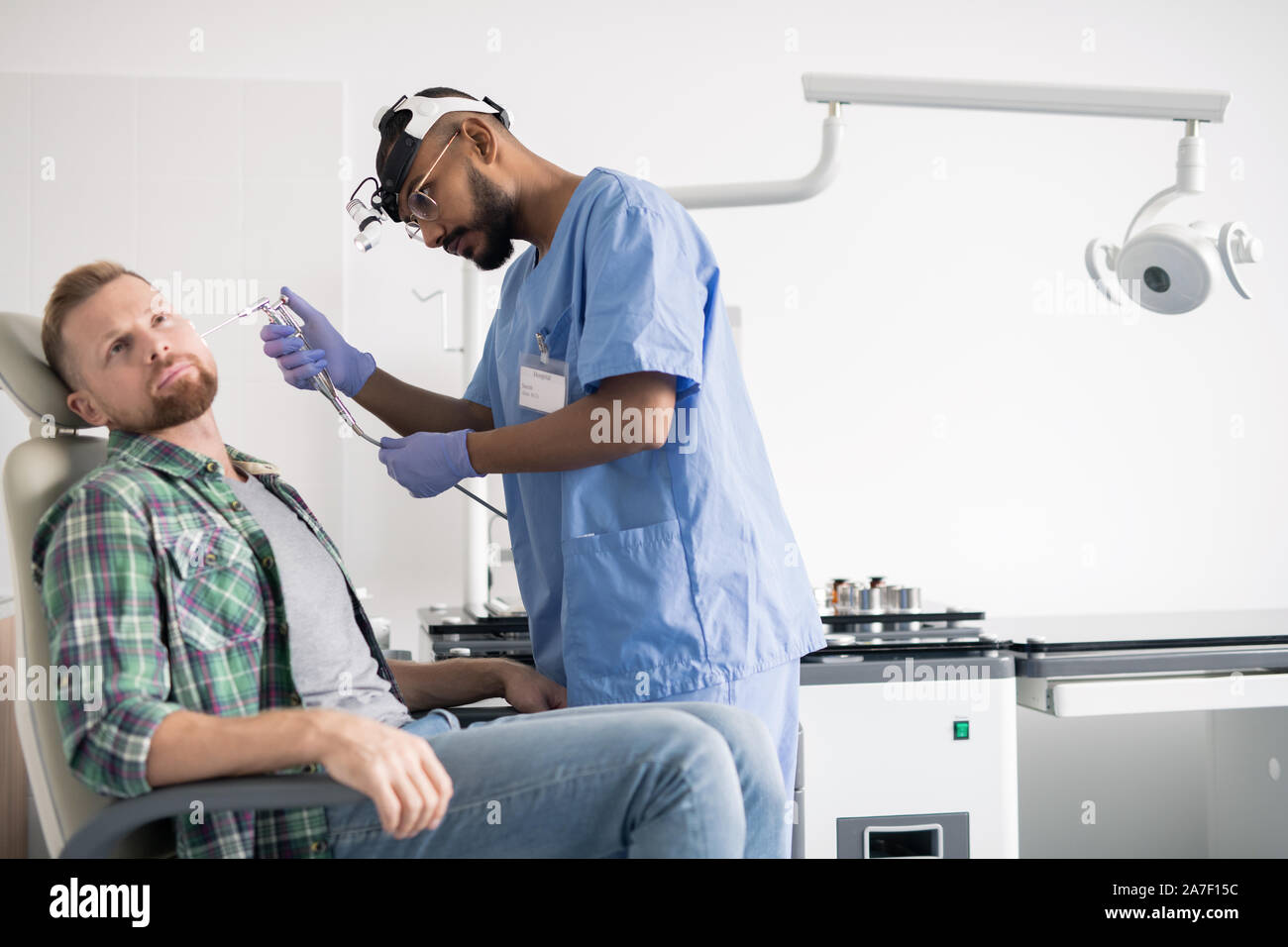Contemporary clinician standing by patient during medical or hygenic ...