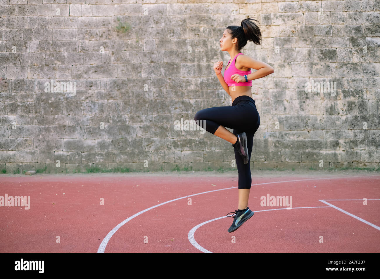 Woman doing jumping exercise at a playfield Stock Photo - Alamy