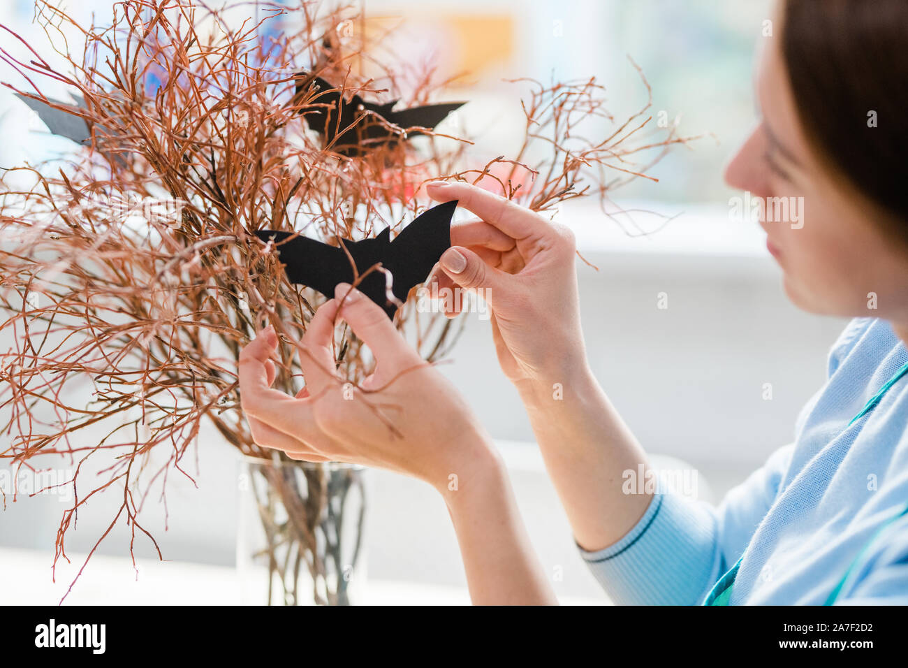 Hands of young female holding black handmade bat and hanging it on ...
