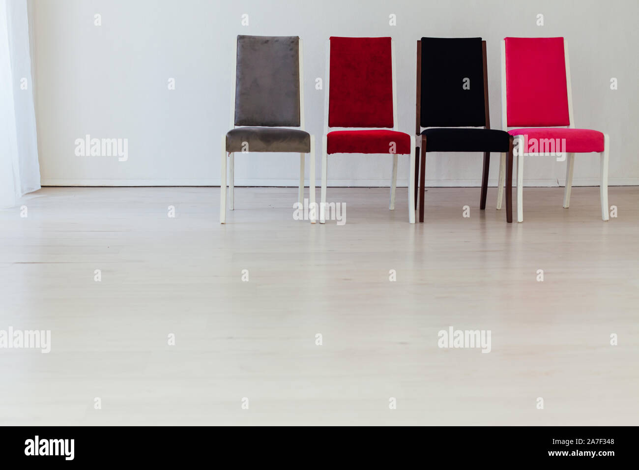 four vintage chairs in an empty white room Stock Photo - Alamy