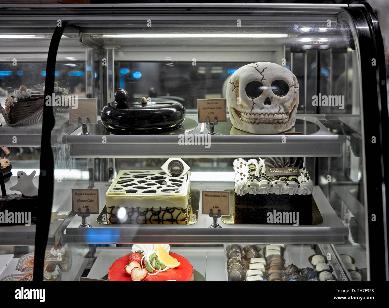 Halloween cake display featuring a human skull cake Stock Photo - Alamy