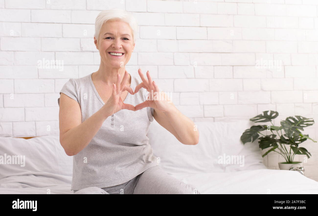 Cute senior woman making heart shape with her hands and fingers Stock ...