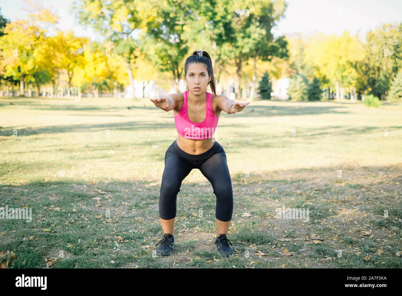 Fit woman demonstrating a proper squat exercise Stock Photo - Alamy