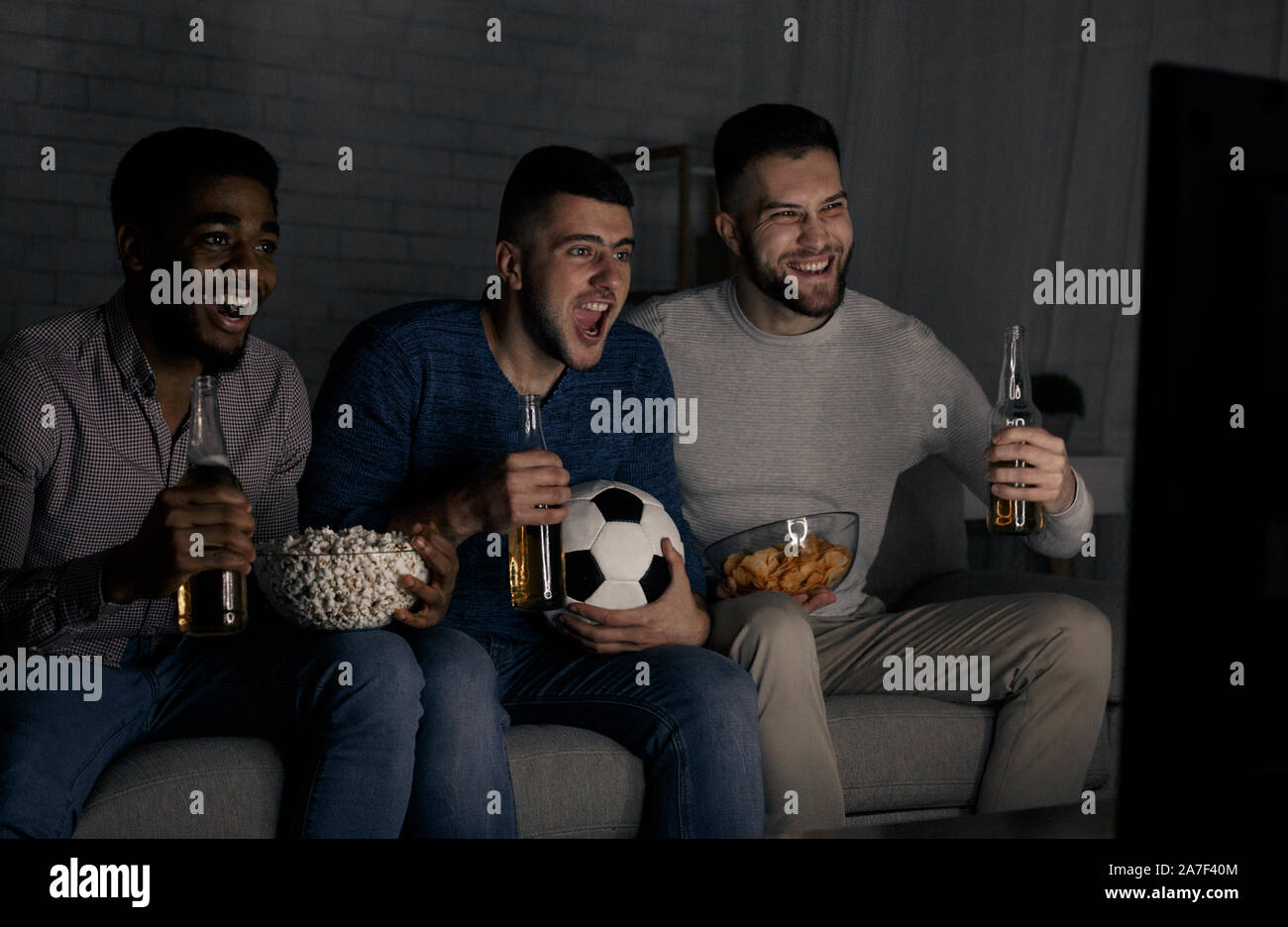 Diverse men watching football match at home Stock Photo - Alamy