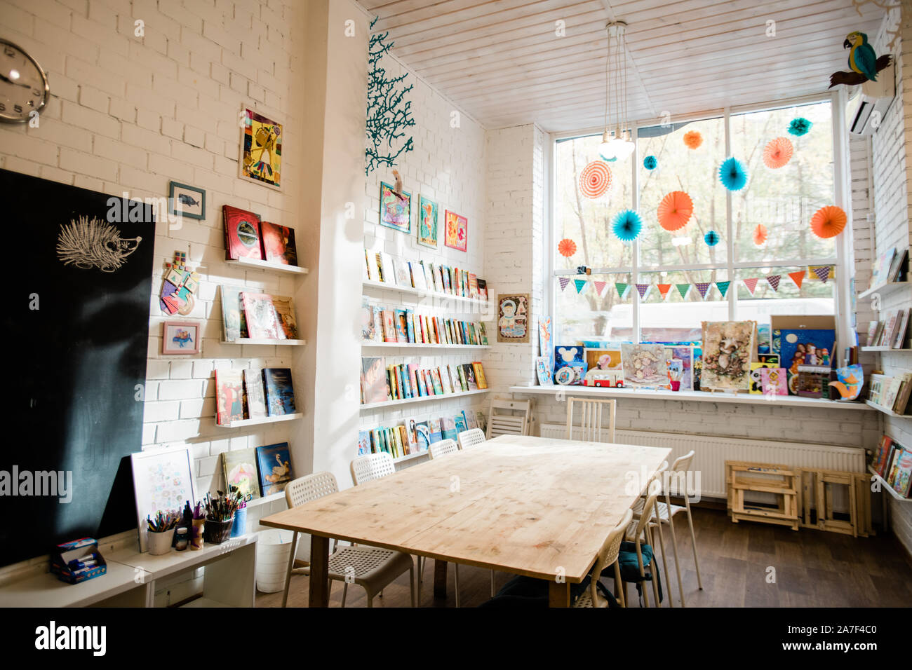 Books on the shelf and paintings on the wall interior hi-res stock ...