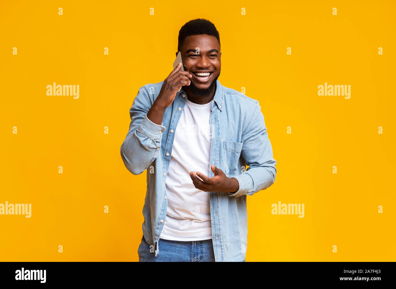 Cheerful black guy talking on phone and laughing out loud Stock Photo ...