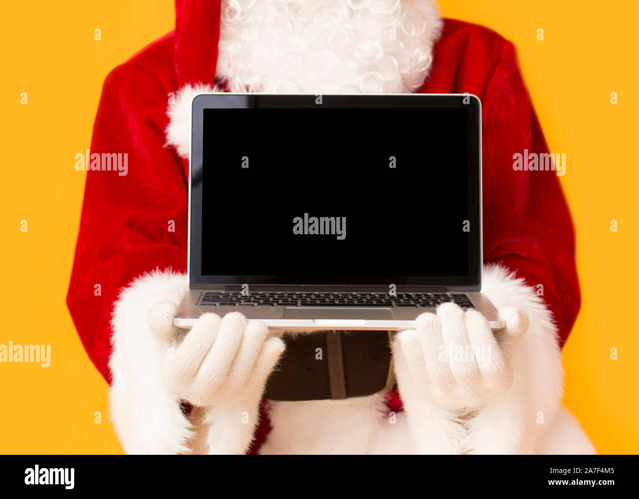 Santa Claus holding open laptop with black blank screen Stock Photo - Alamy